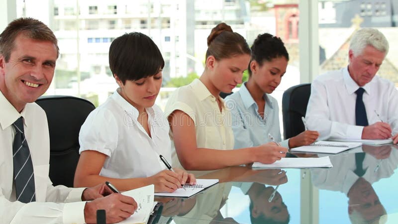 Business People Taking Notes while Sitting at a Meeting Table Stock ...