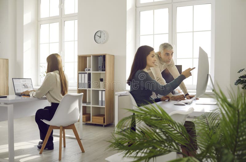 Business People Using Computers while Working Together in a Modern ...