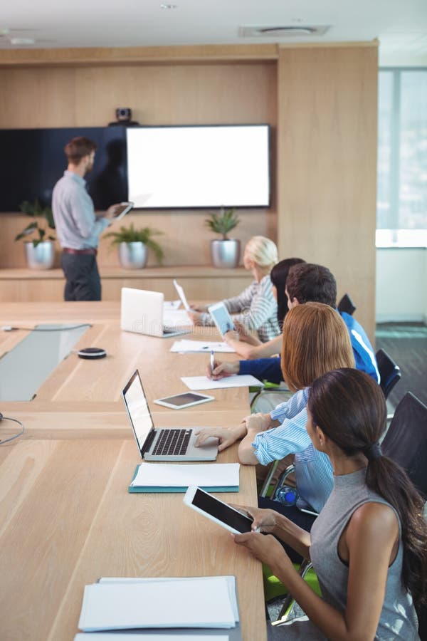 Business People Using Laptop and Digital Tablets at Conference Table ...