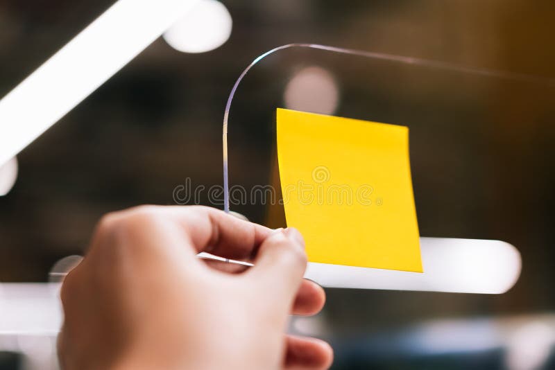 Business People Using Sticky Note on Plexiglass Separators To Share ...