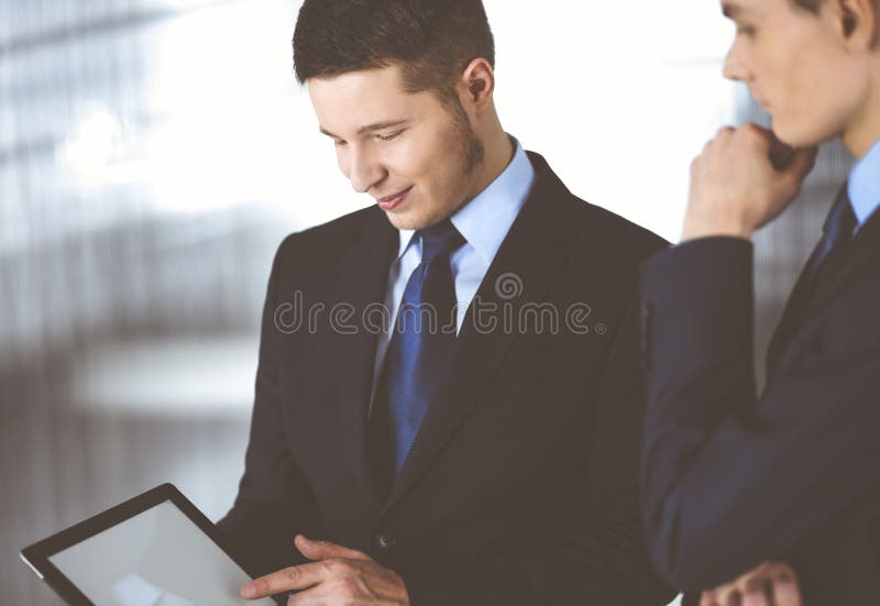 Business People are Using a Tablet Computer, while Standing in a Modern ...