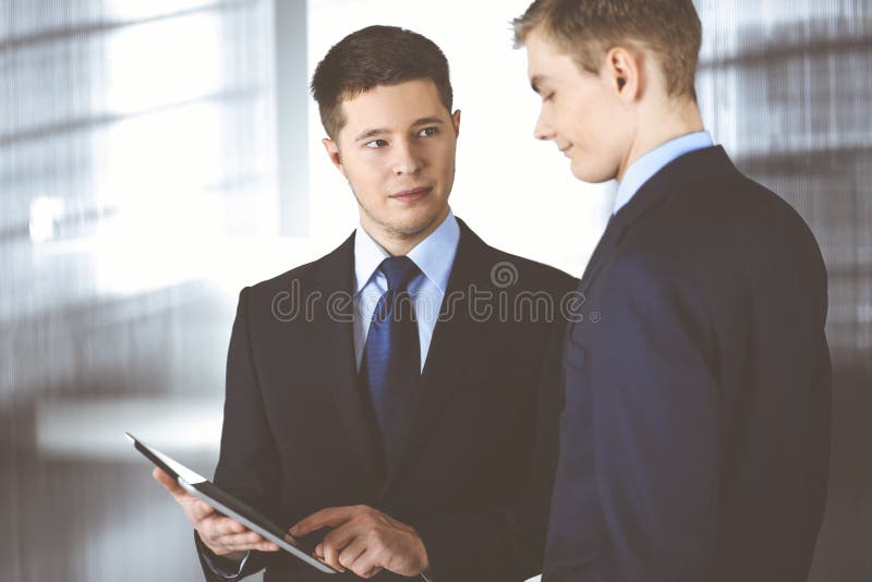 Business People are Using a Tablet Computer, while Standing in a Modern ...