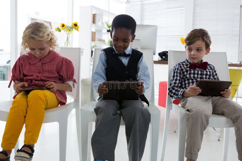 Business People Using Tablet Computers while Sitting on Chair in Office ...