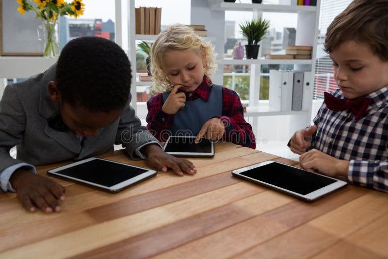 Business People Using Tablet Computers while Sitting at Table in Office ...
