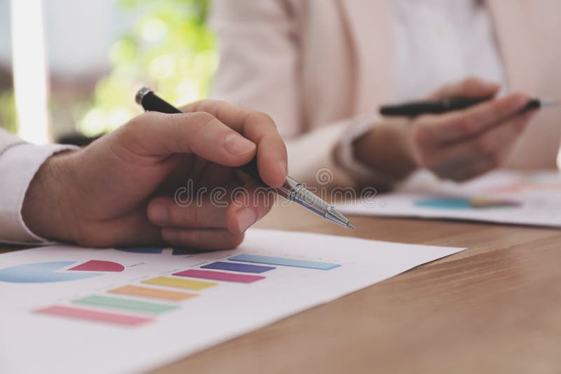 Business People Working with Charts and Graphs at Table in Office ...
