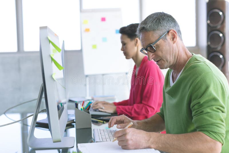 Business People Working on Computer at Desk in Office Stock Photo ...