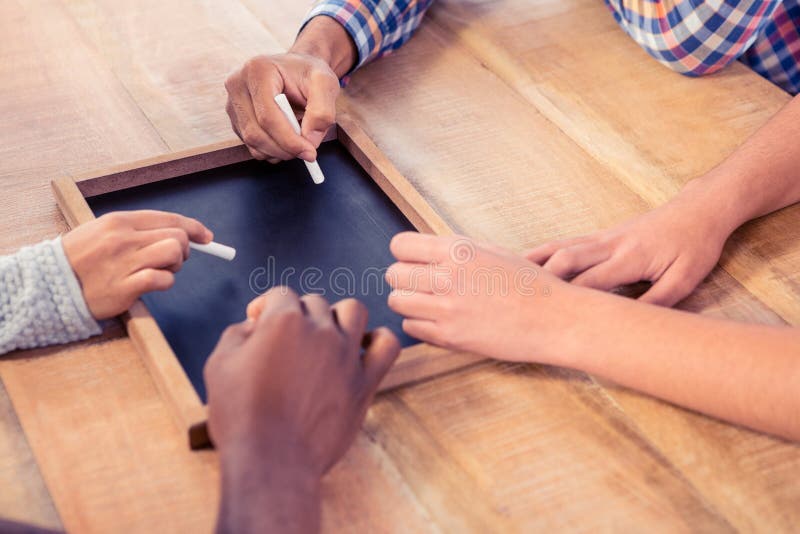 Business People Writing on Slate with Chalk at Desk Stock Image - Image ...