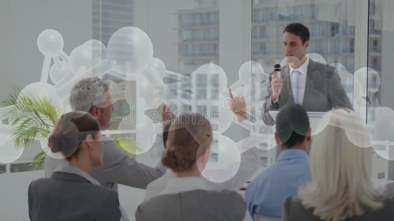 Business Presenter Using Microphone at Podium with Audience Raising ...