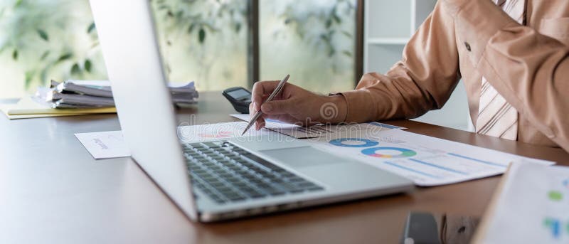 Business Professional Reviewing Financial Reports on Laptop, Analyzing ...