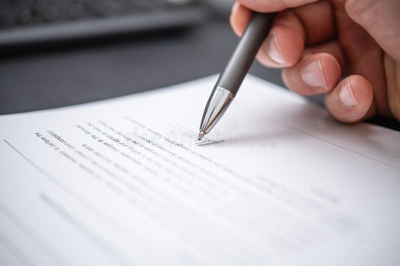 Business Professional Signing Important Legal Documents with a Pen on a ...