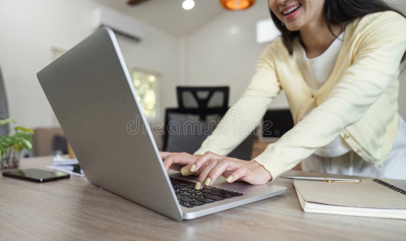 Business Professional Typing on Laptop while Reviewing Documents at ...