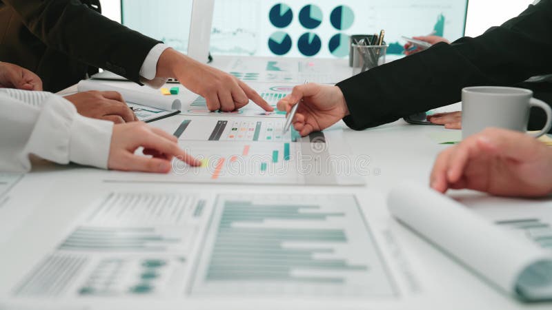 Business Professionals Analyzing Data and Statistics during a Meeting ...