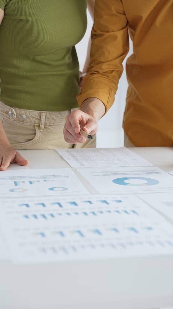 Business Professionals Analyzing Financial Reports, Pointing at Data ...