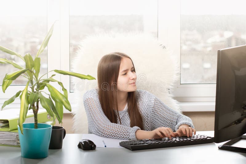 Business at a Remote Work. a Young Girl Sits at a Table Typing on a ...
