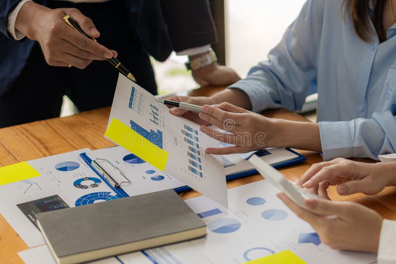 Business Team Discussing and Planning Projects Using Charts, Holding ...