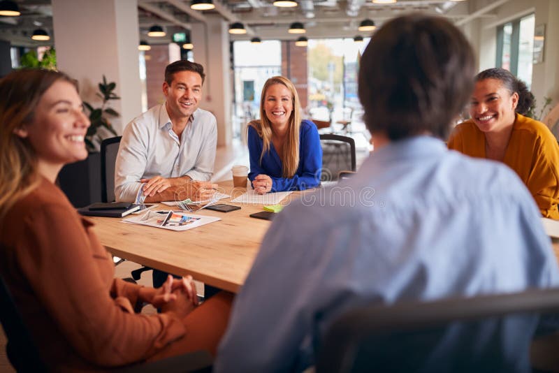 Business Team Having Meeting Sitting Around Table in Modern Open Plan ...