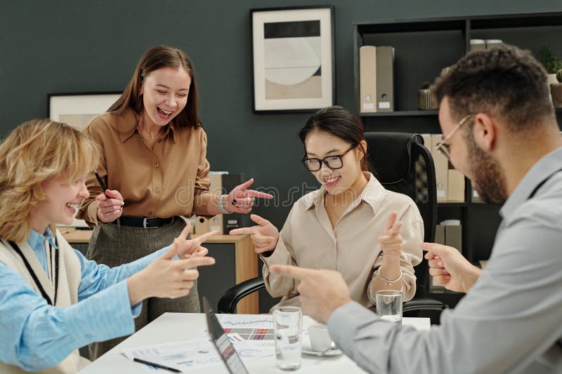 Business Team Pointing at Each Other Smiling Cheerfully Stock Photo ...