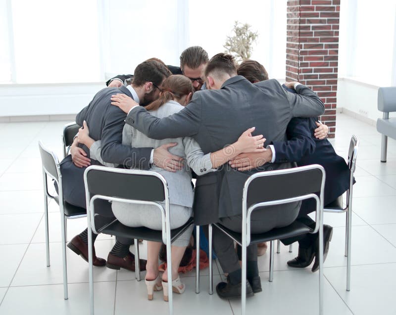 Business Team Sits in a Circle and Hugs Each Other Stock Photo - Image ...