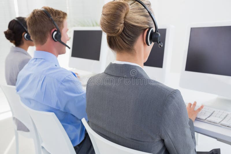 Business Team Working on Computers and Wearing Headsets Stock Image ...