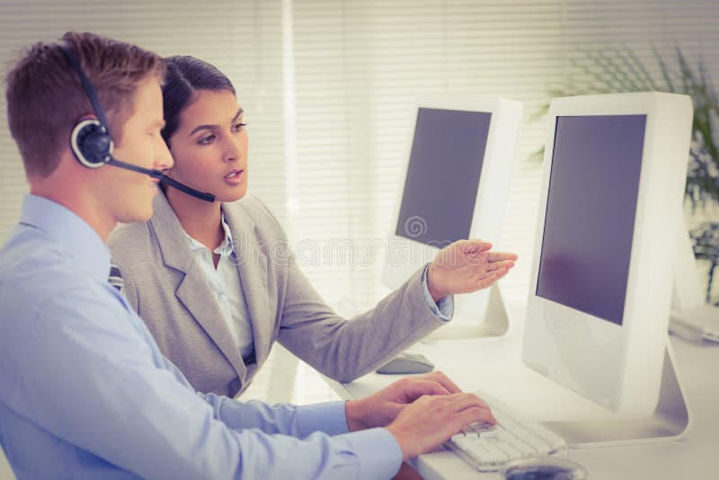Business Team Working on Computers and Wearing Headsets Stock Image ...