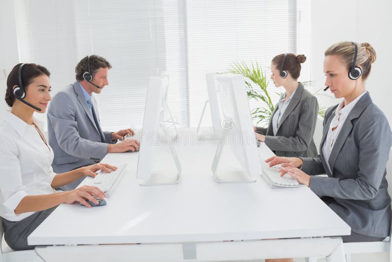 Business Team Working on Computers and Wearing Headsets Stock Photo ...
