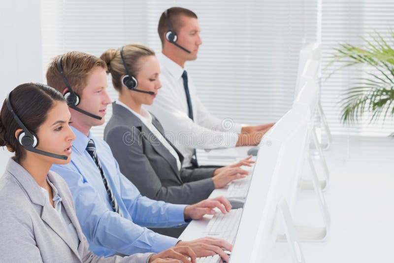 Business Team Working on Computers and Wearing Headsets Stock Photo ...