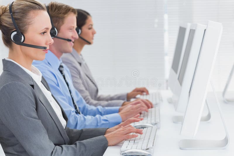 Business Team Working on Computers and Wearing Headsets Stock Photo ...