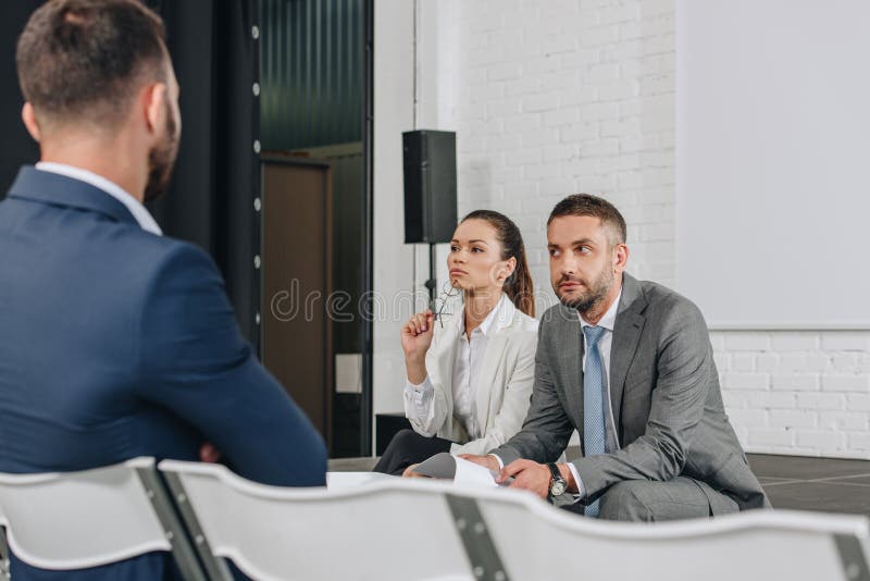 Business Trainers Sitting on Stage with Documents Stock Image - Image ...