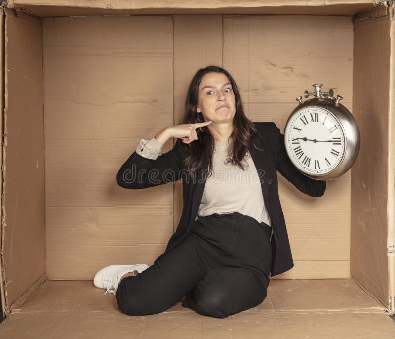 Business Woman with a Clock in Hand Sits in a Cardboard Office Stock ...
