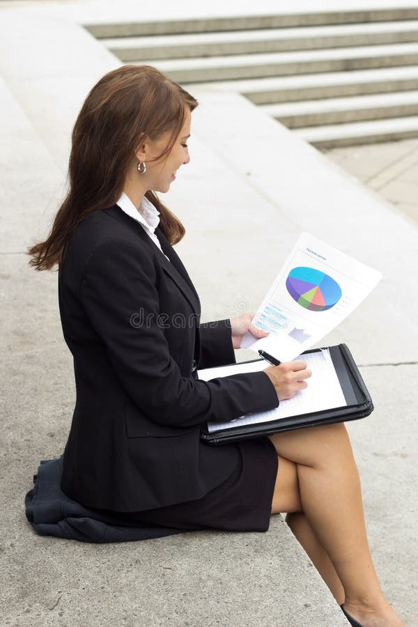 Business Woman Examines Report Document and Writes in Notebook Stock ...