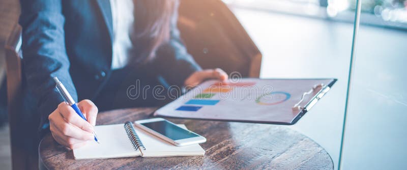 Business Woman Hand Writing on a Notepad and Using Analysis Cha Stock ...
