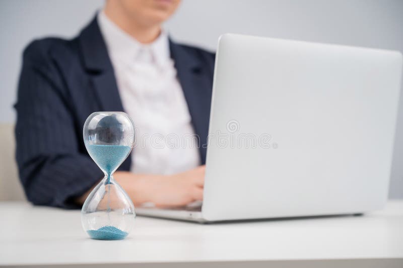 Business Woman Keeps Track of Time on an Hourglass while Working. Stock ...