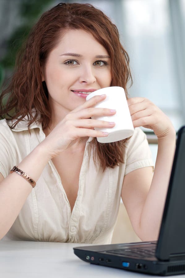Smiling Older Woman Drinking Coffee and Looking at Laptop Stock Photo ...