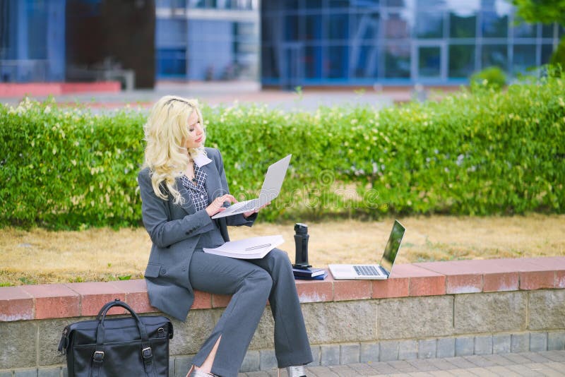 Business Woman in an Office Suit Working Outside with a Laptop Compute ...