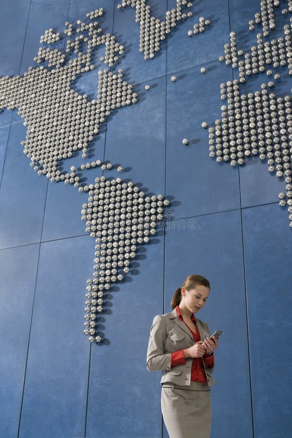 Business Woman Using Mobile Phone in Front of World Map in Office Stock ...