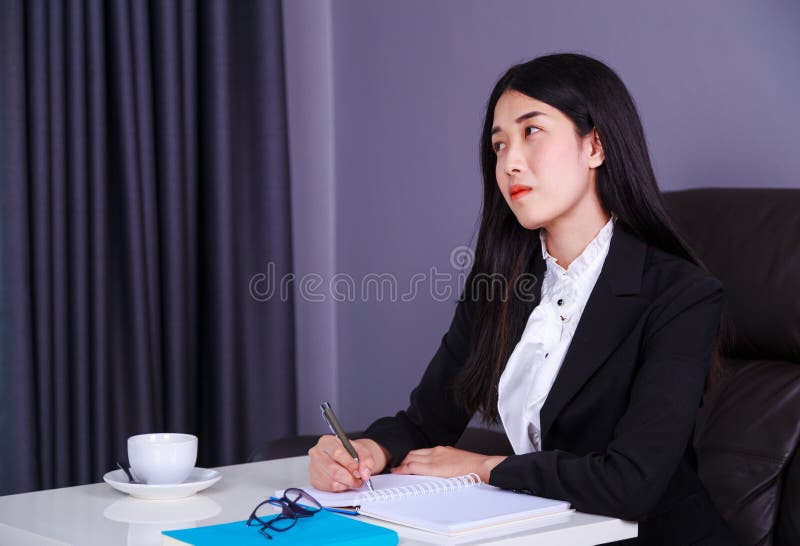 Business Woman Thinking and Writes a Note on the Notebook Stock Photo ...