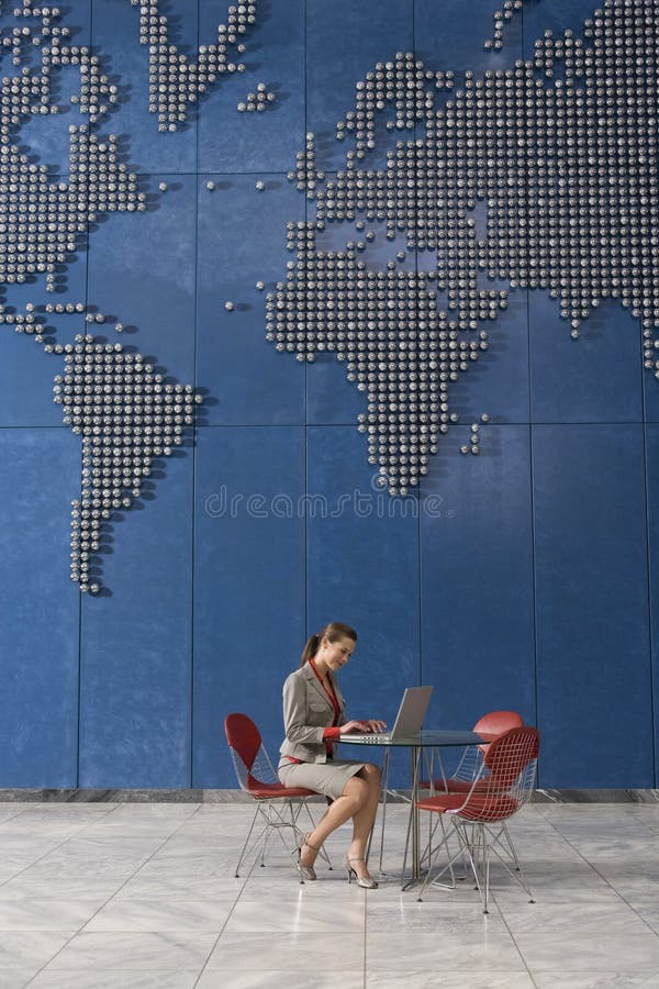Business Woman Using Laptop in Office with World Map on Wall Stock ...