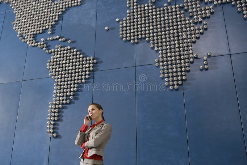 Business Woman Using Mobile Phone in Front of World Map in Office Stock ...