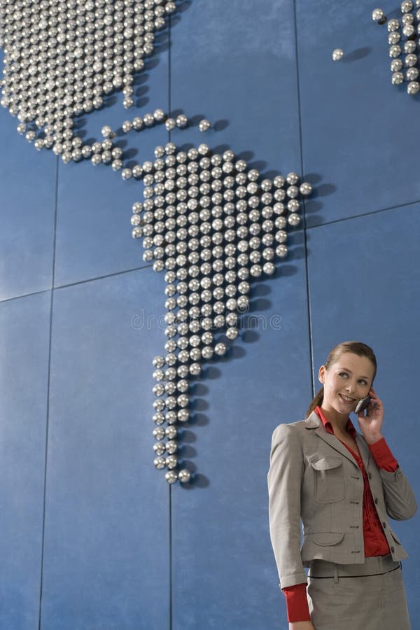 Business Woman Using Mobile Phone in Front of World Map in Office Stock ...