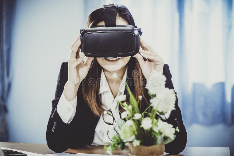 Business Woman Using a VR Headset for Work with Virtual Reality, with ...