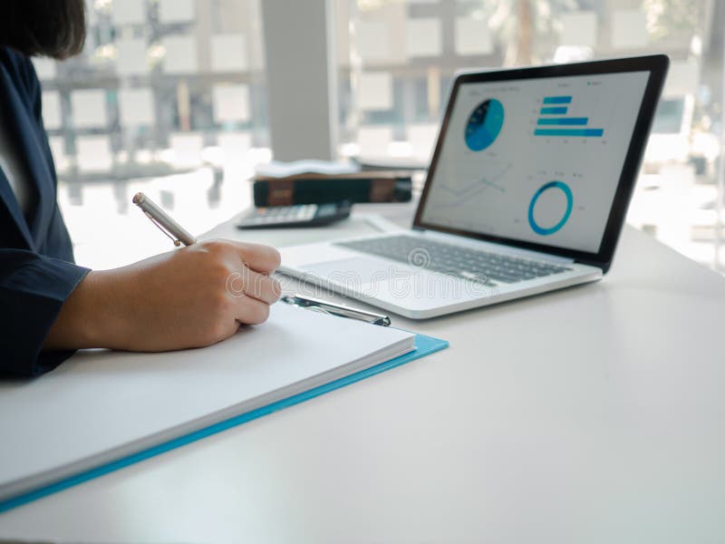 Business Woman Working at a Computer, Writing a Note in Chart. Finance ...