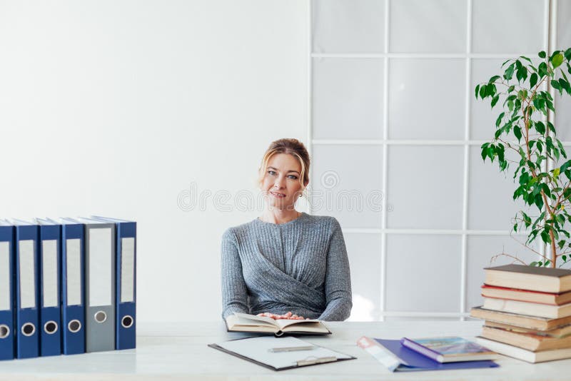 Business Woman Working at a Desk in the Office with Books Training ...