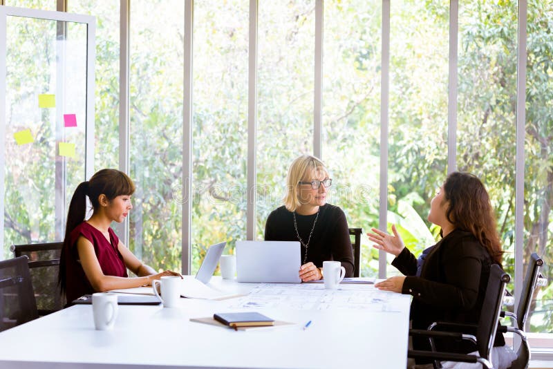 Business Women Discussing at Table in Office Stock Photo - Image of ...