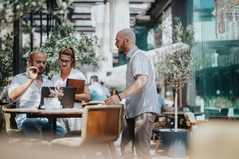 Business Workers Collaborating Together in a Coffee Bar, Brainstorming ...