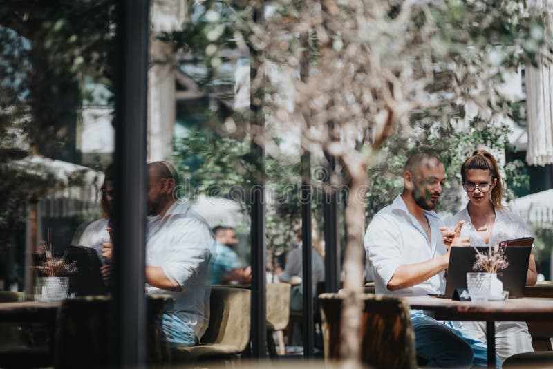 Business Workers Collaborating on a Project in a Coffee Bar ...