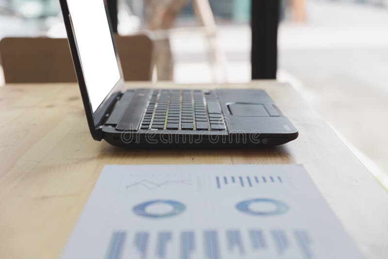 Business Workplace with Laptop Computer and Paper with Graphs an Stock ...