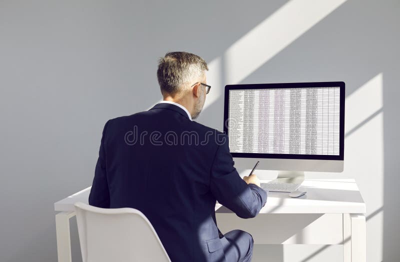 Businessman or Accountant at Workplace Compares Data on Electronic ...