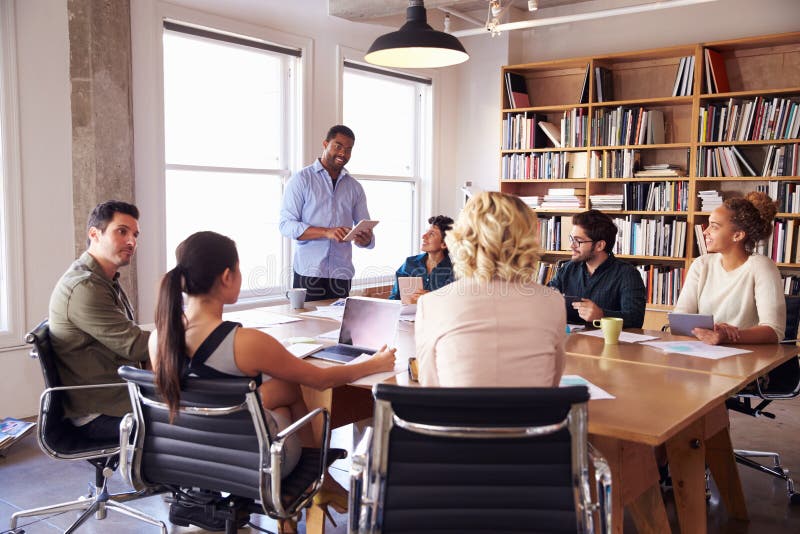 Businessman Addressing Team Meeting Around Table Stock Photo - Image of ...