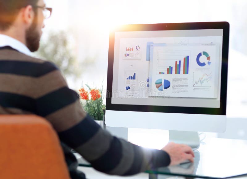 Businessman Analyzing Graphs on Computer at Desk Stock Photo - Image of ...