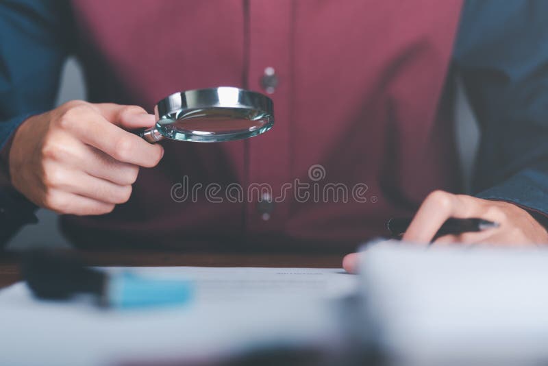 Businessman Audit Documents with a Magnifying Glass, Quality Assessment ...